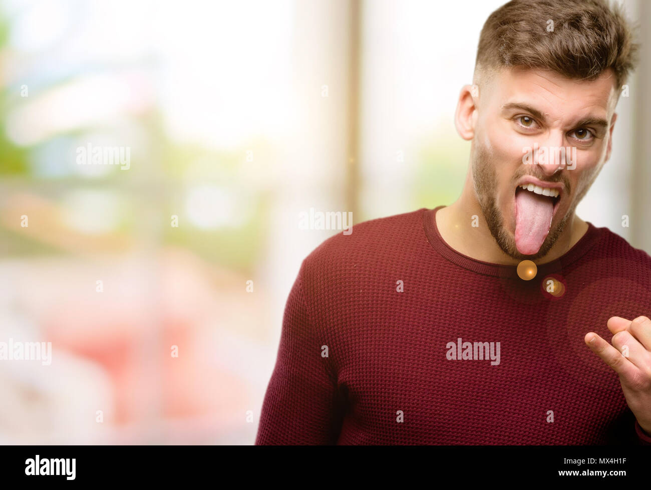 Handsome young man making rock symbol with hands, shouting and ...