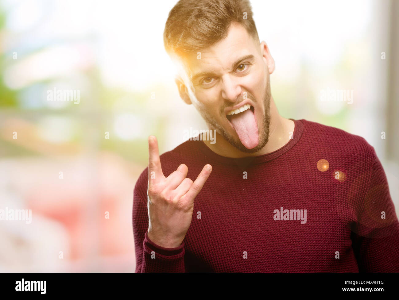 Handsome young man making rock symbol with hands, shouting and ...
