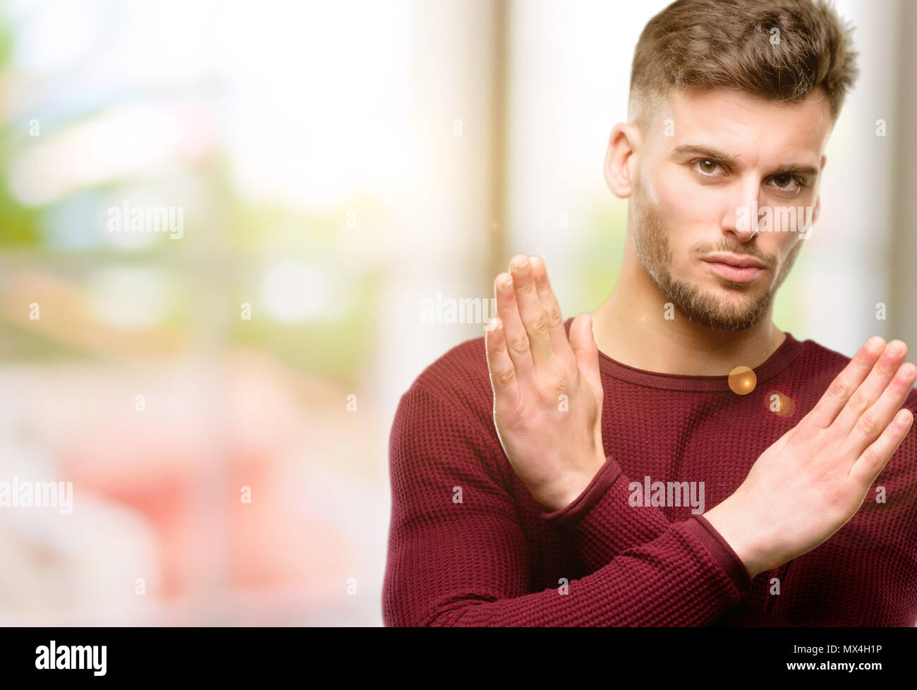 Handsome young man annoyed with bad attitude making stop sign crossing ...
