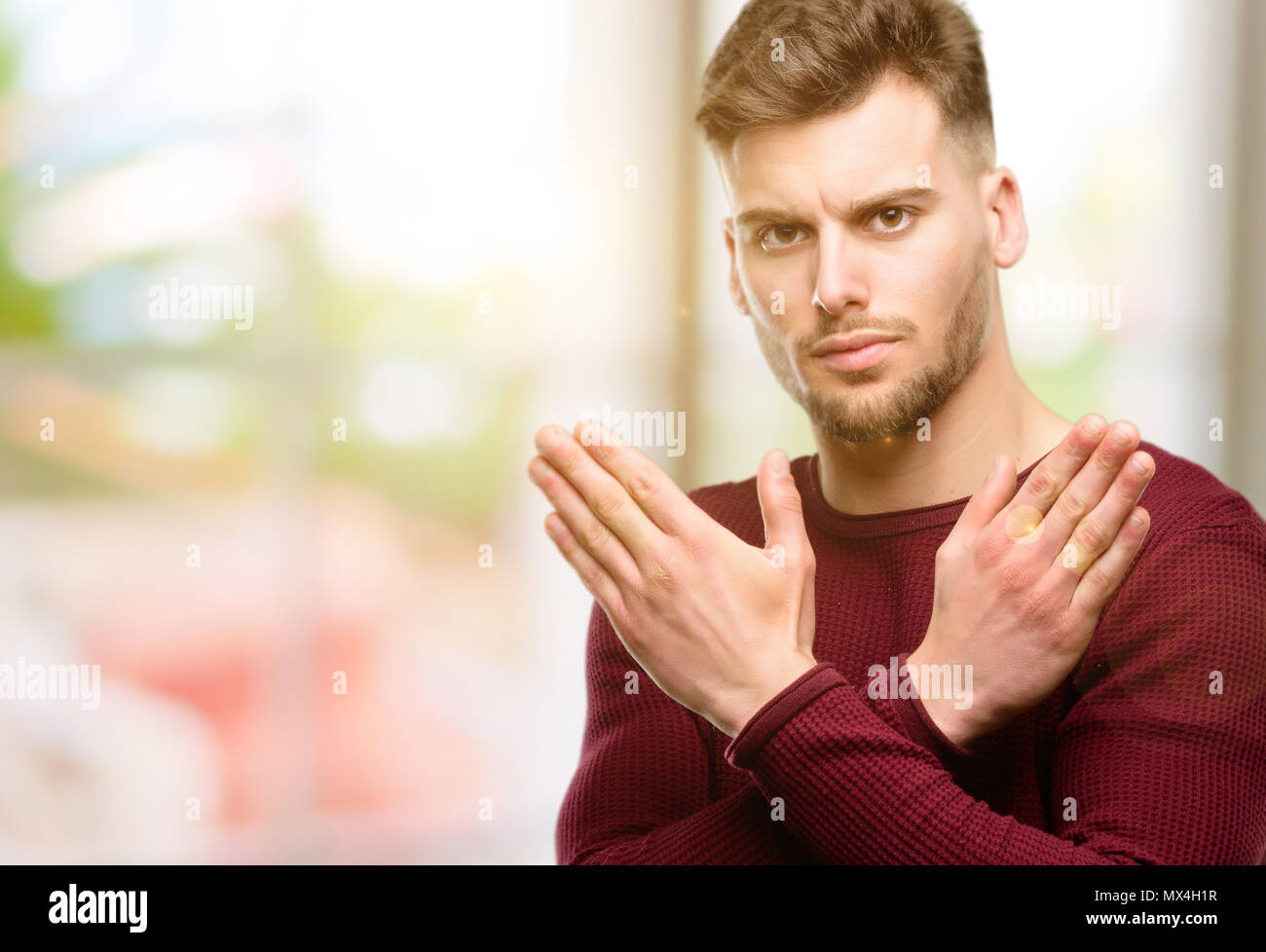 Handsome young man annoyed with bad attitude making stop sign crossing ...