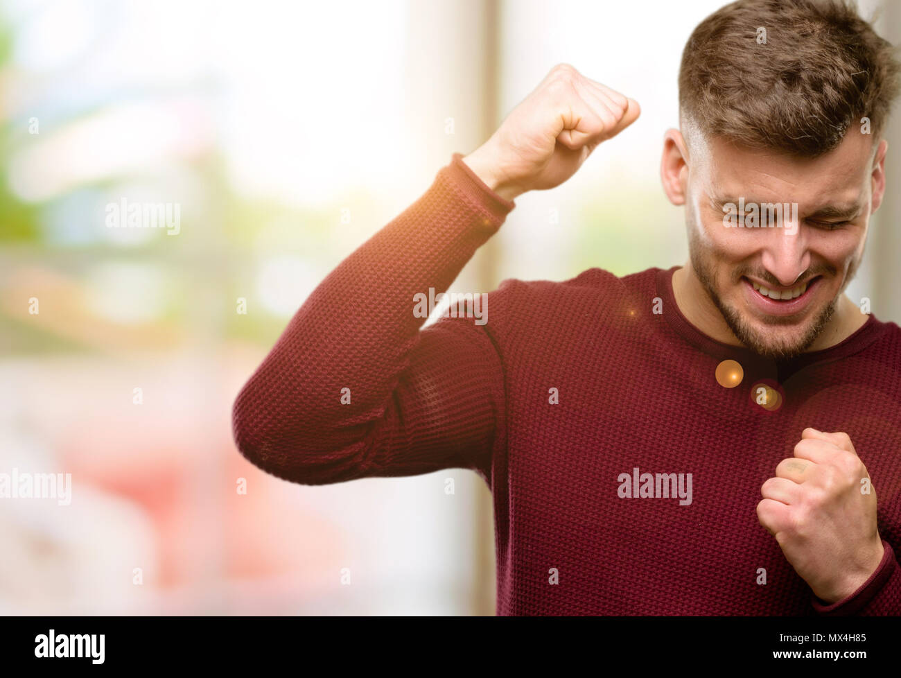 Handsome young man happy and excited expressing winning gesture ...