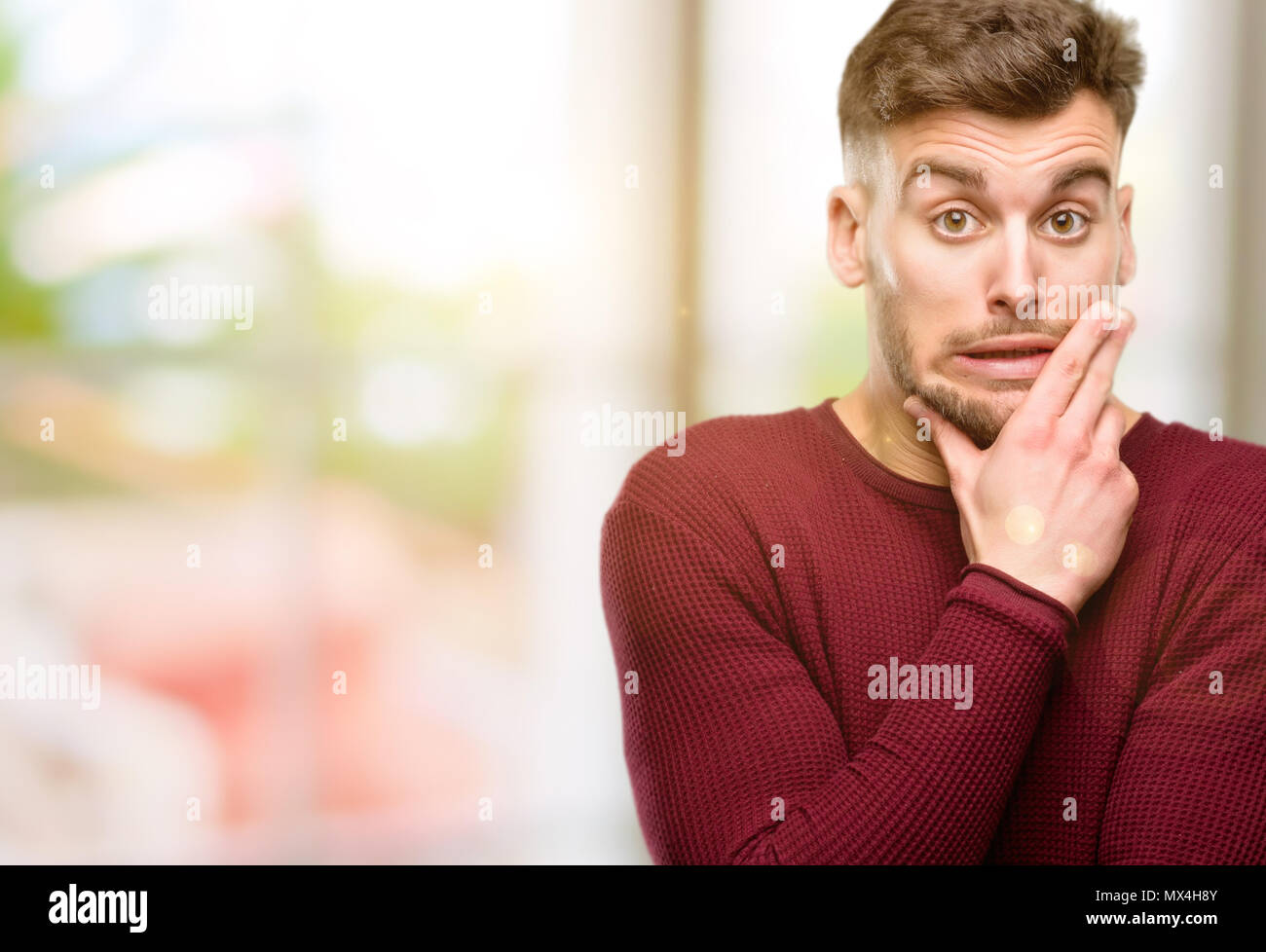 Handsome young man scared in shock, expressing panic and fear Stock ...