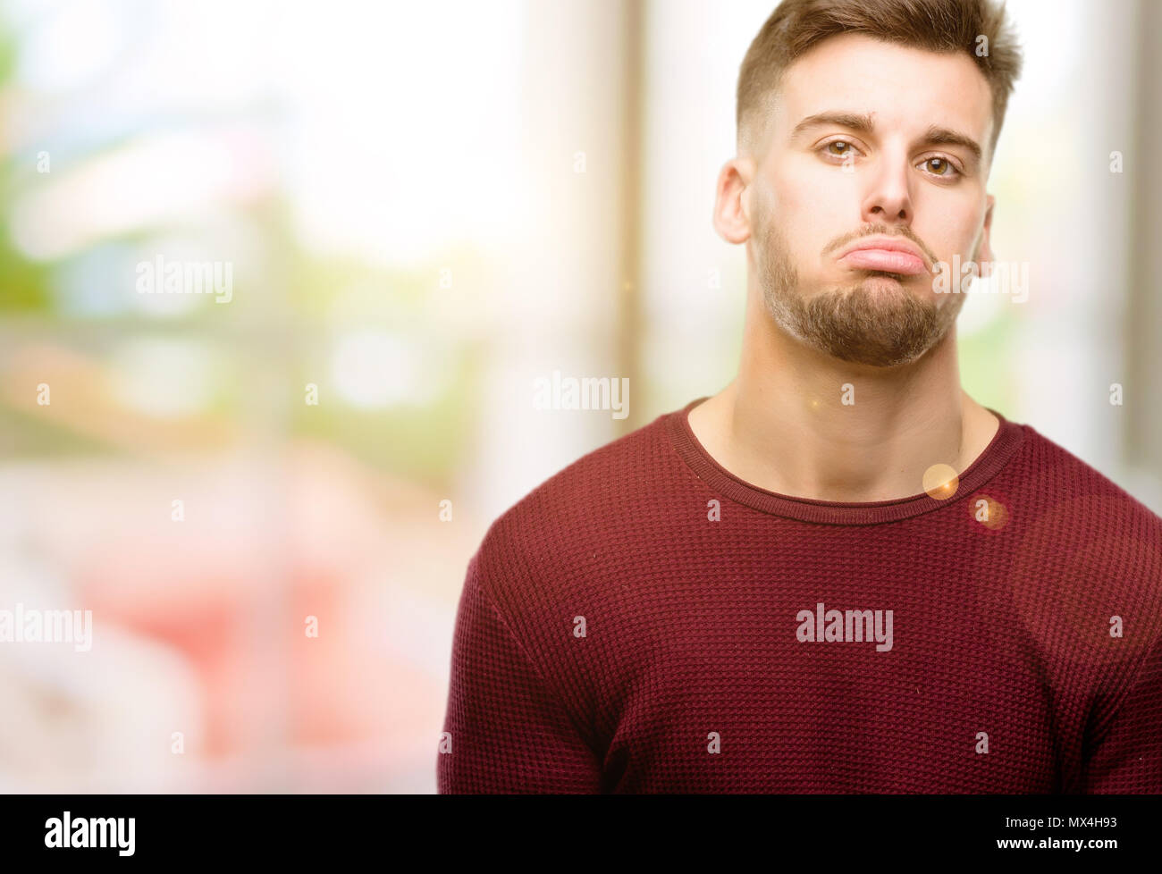 Handsome young man with sleepy expression, being overworked and tired ...