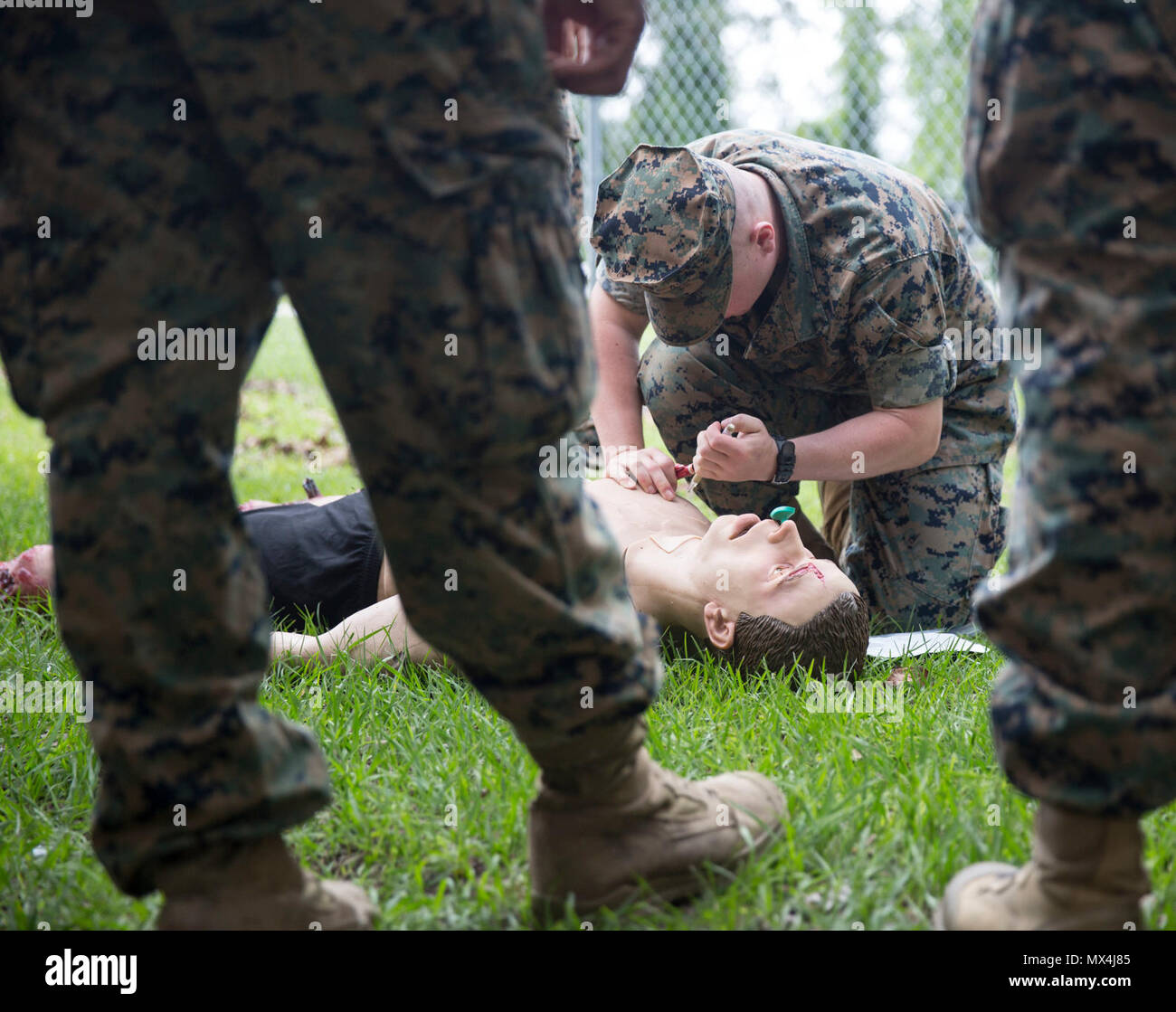 A Marine inserts a catheter into a notional casualty’s chest under the supervision of his ...