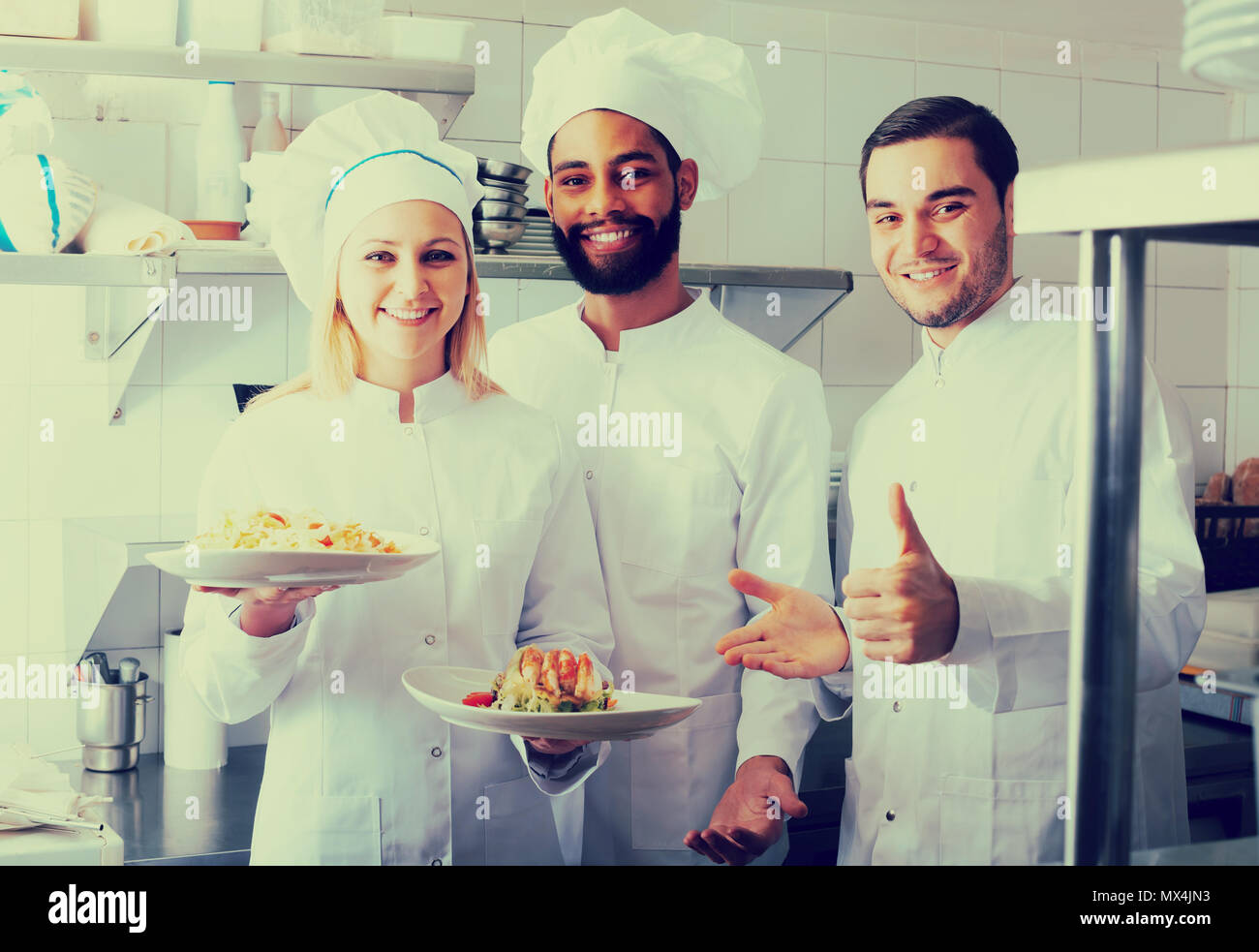 Crew of happy spanish professional cooks working at restaurant kitchen ...