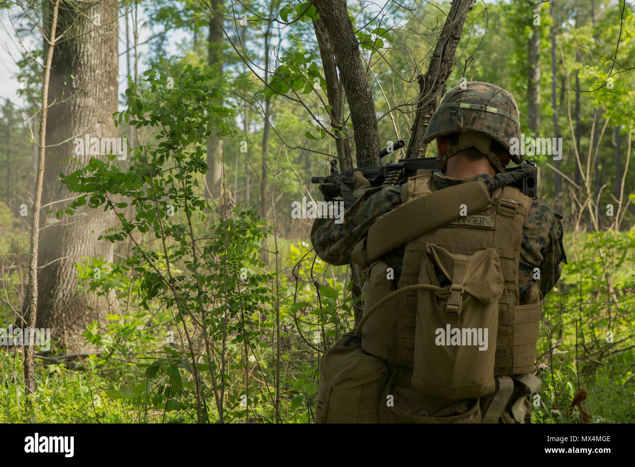 A Marine fires an M249 light machine gun at a target during a company ...