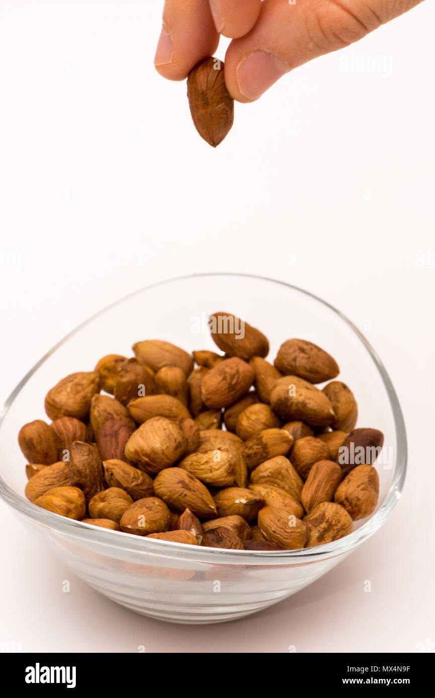 Hazelnuts or Nuts without shell and hand taking on isolated white ...