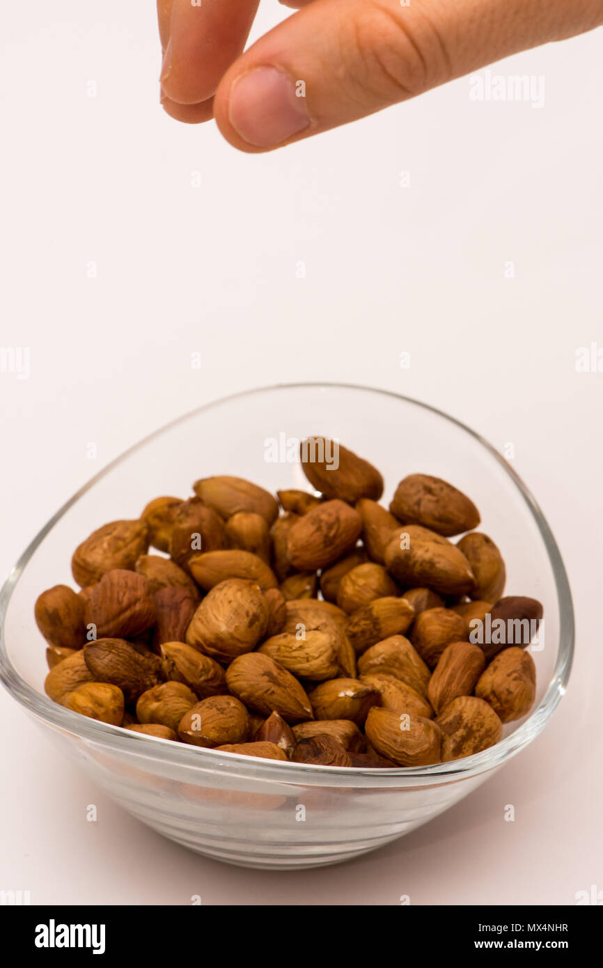 Hazelnuts or Nuts without shell and hand taking on isolated white ...