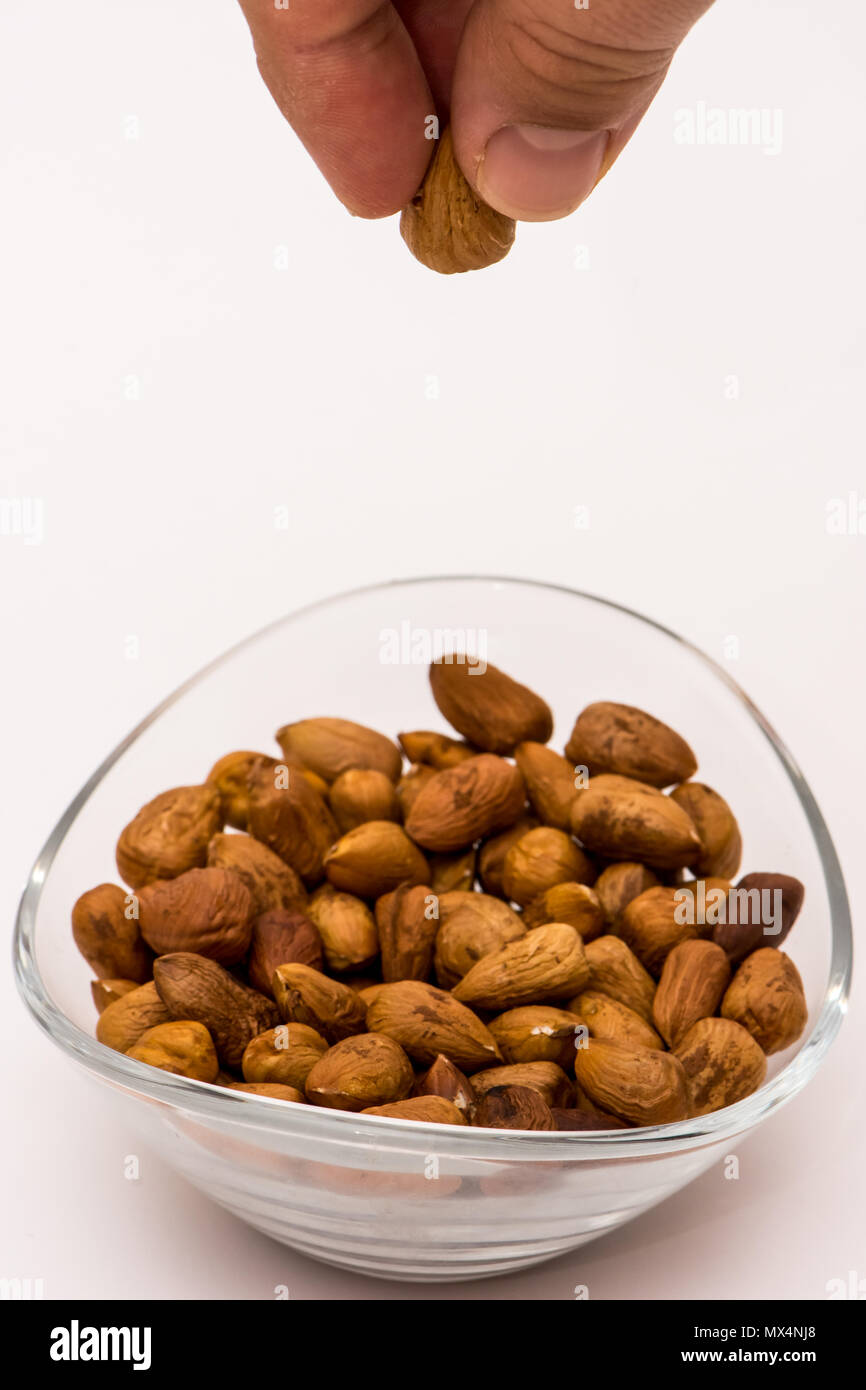 Hazelnuts or Nuts without shell and hand taking on isolated white ...