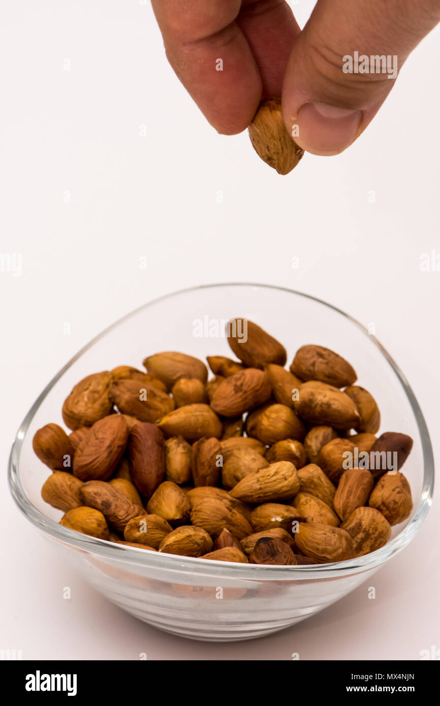 Hazelnuts or Nuts without shell and hand taking on isolated white ...