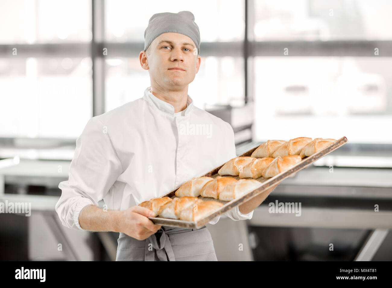 Baker with buns at the manufacturing Stock Photo - Alamy