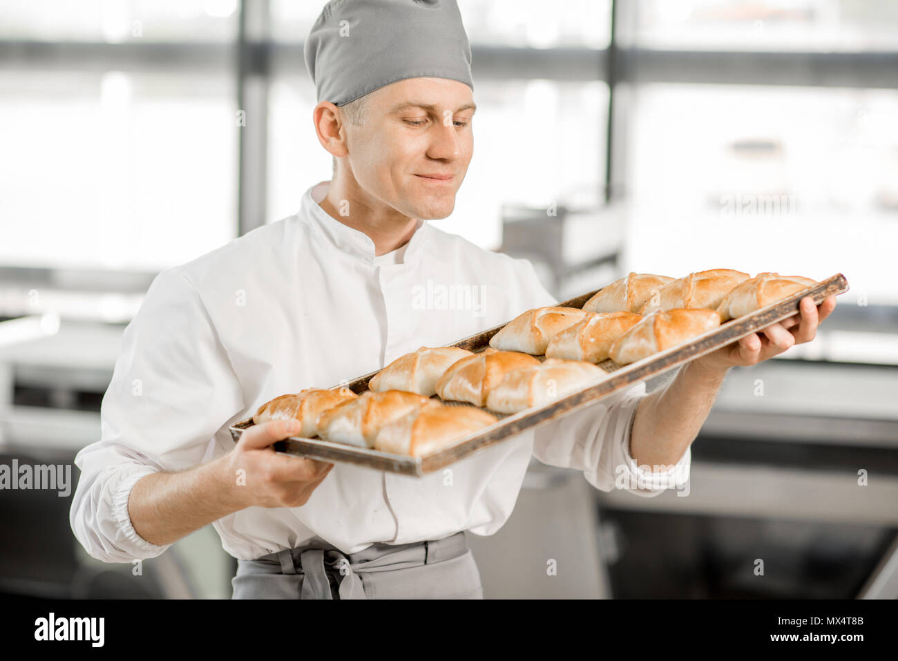 Baker with buns at the manufacturing Stock Photo - Alamy