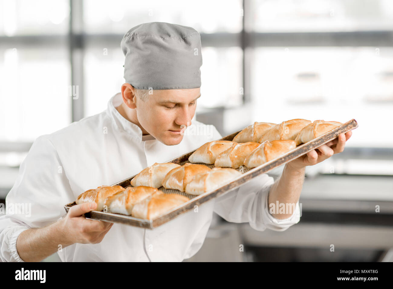 Baker with buns at the manufacturing Stock Photo - Alamy