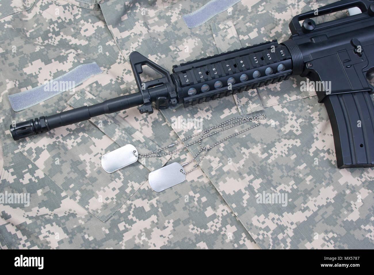 M4A1 RIS assault carbine with blank dog tags on camouflage uniform ...