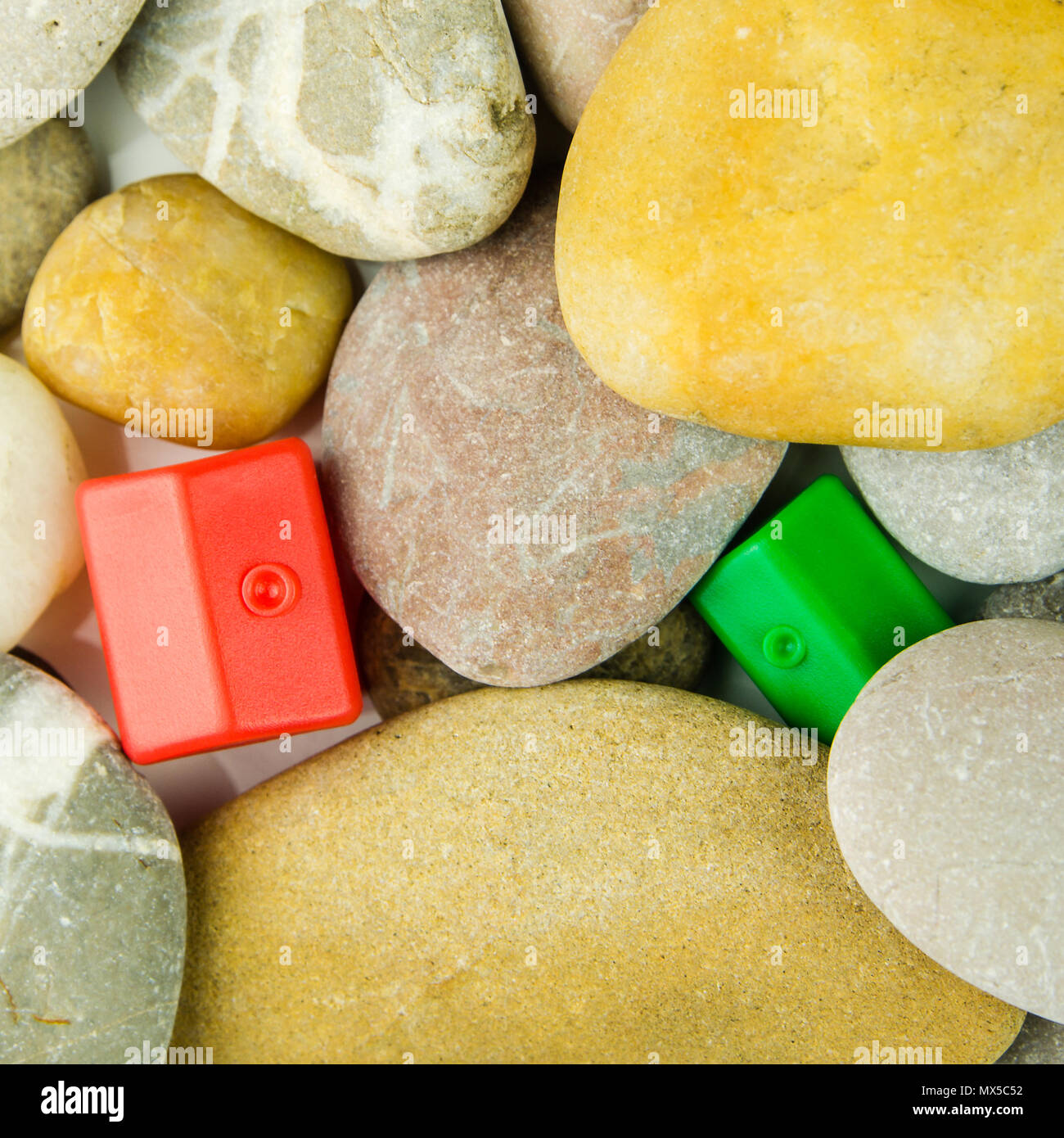 two red and green miniatures of plastic houses laying under differrent ...