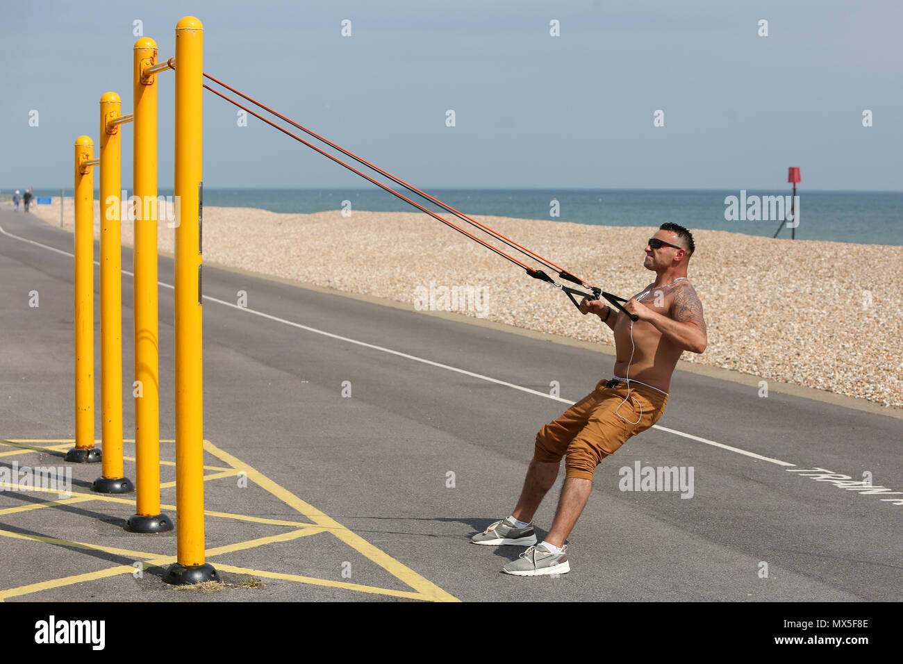 A man pictured using outdoor exercise equipment on the beach in Bognor ...