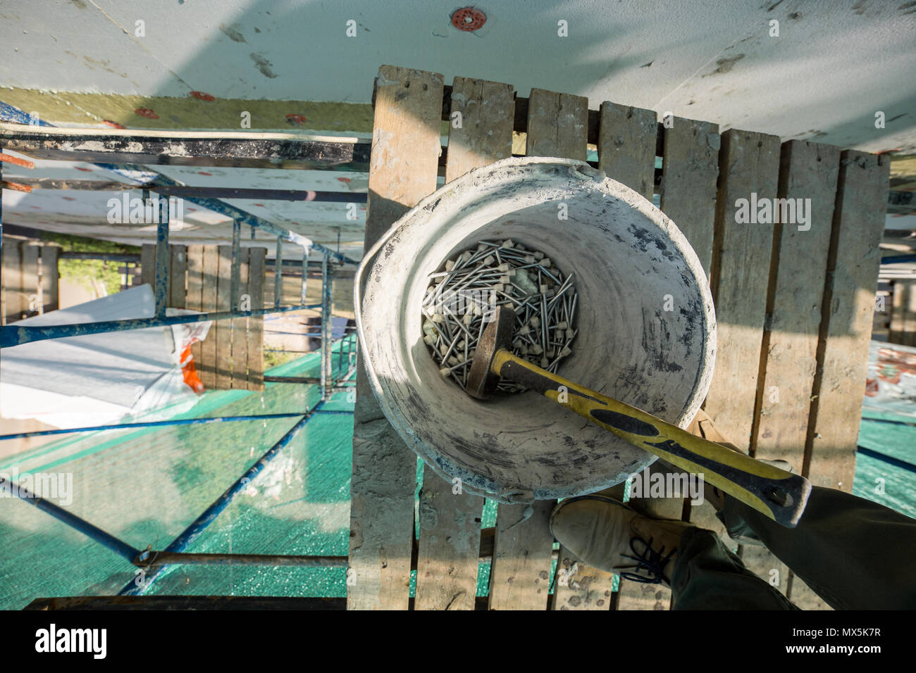 Top view on bucket with dowels on high-altitude scaffolding. Work on ...