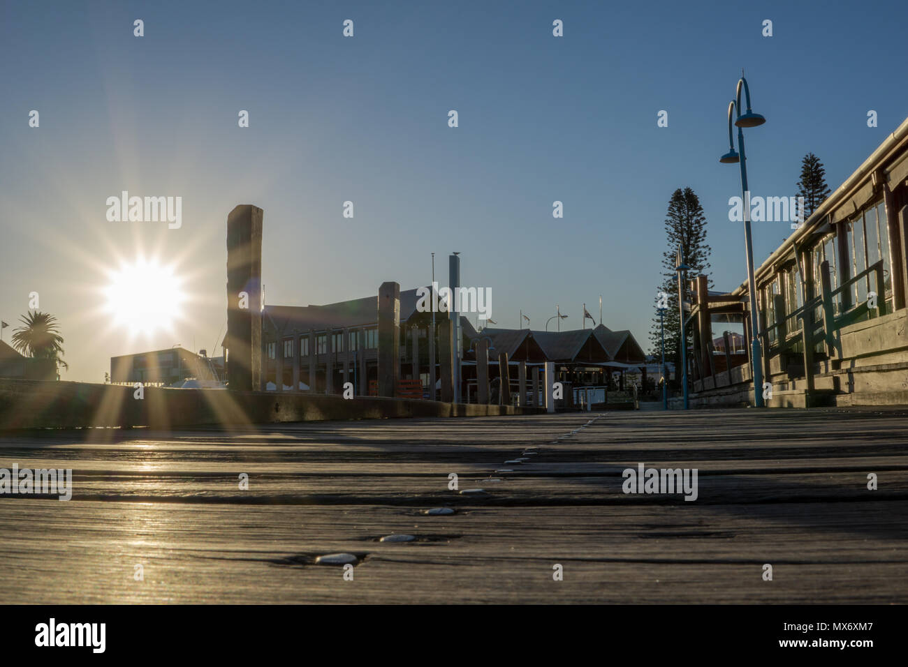 FREMANTLE, AUSTRALIA - MAY 8 2018; Sun flare over wooden wharf decking ...