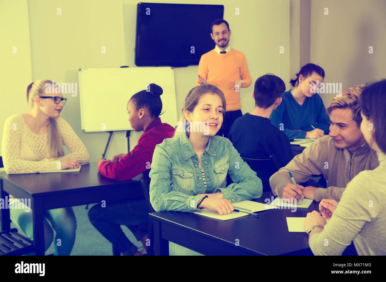Friendly classmates working in groups to complete task during class ...