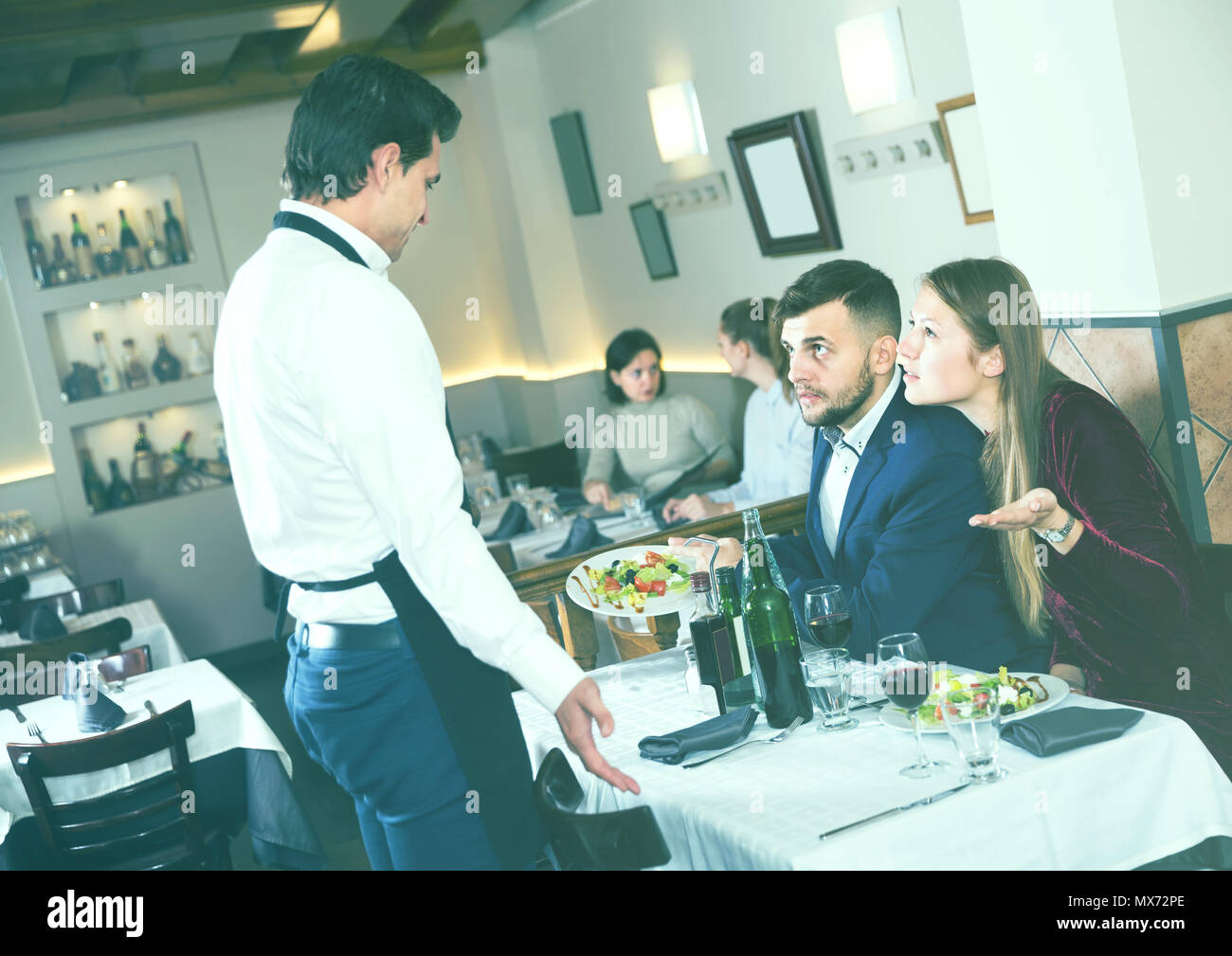 angry guests conflicting with waiter because of poor quality of dish in ...