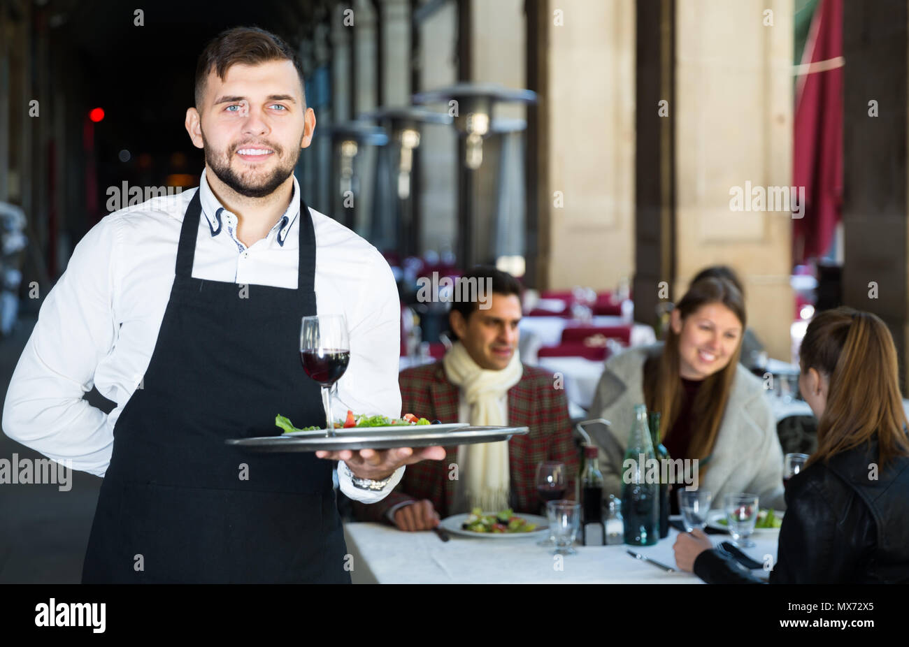 Handsome waiter with serving tray welcoming to cozy restaurant Stock ...