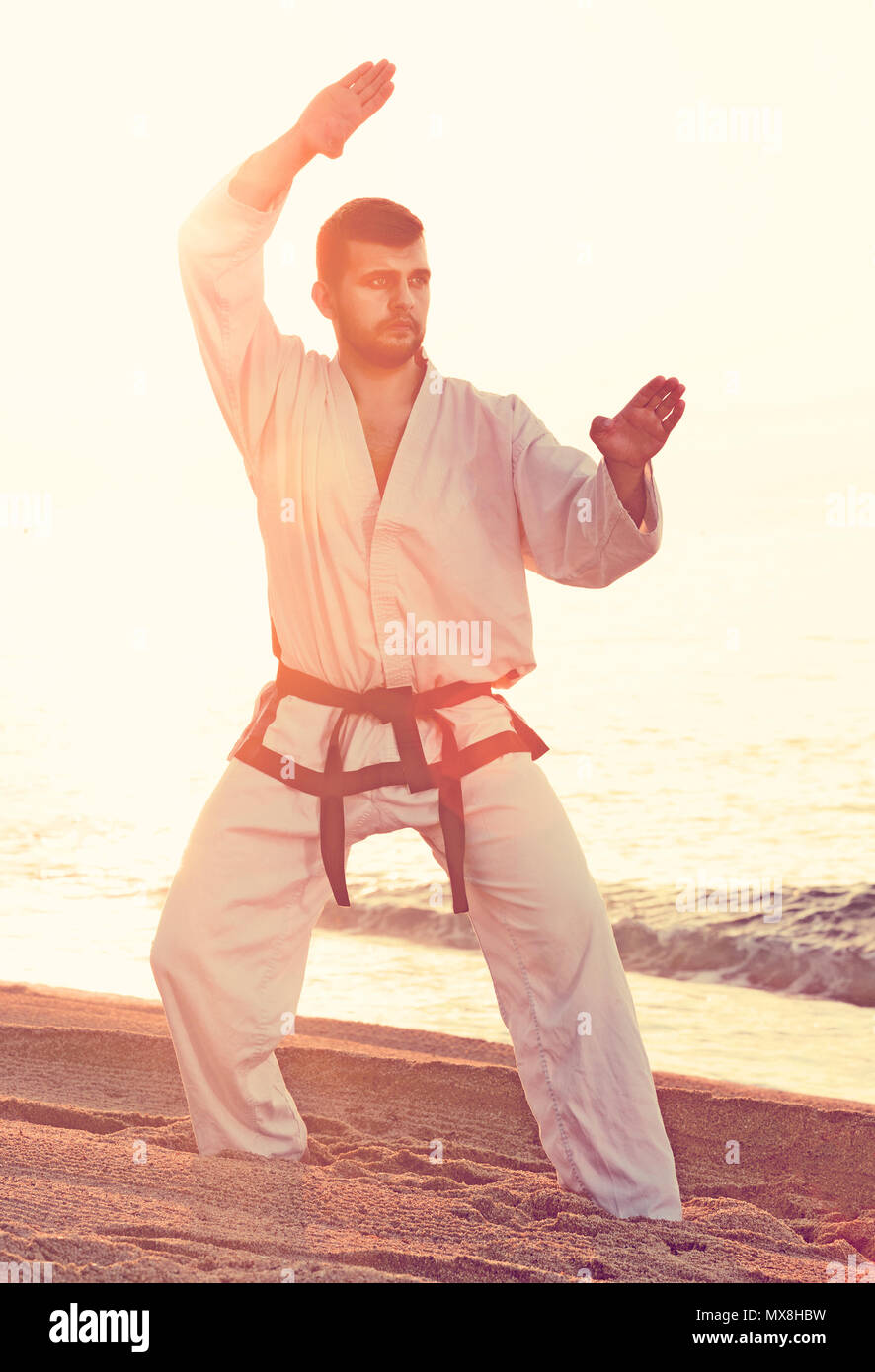 Concentrated man doing karate at ocean quay in dawn Stock Photo - Alamy