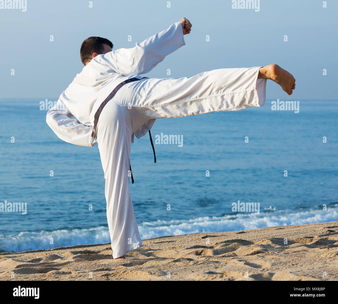 Young guy training karate poses at beach in sunny morning outdoor Stock ...