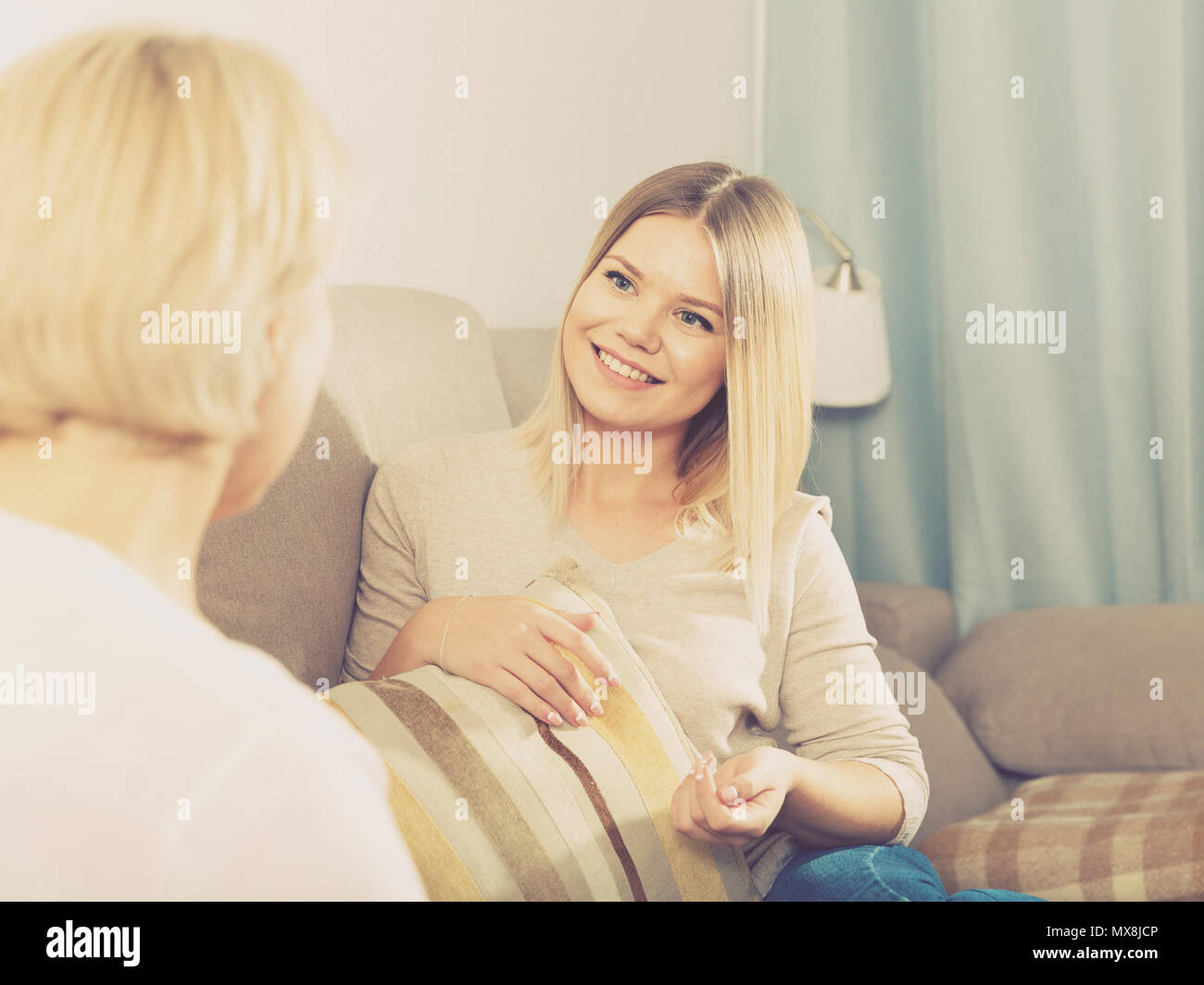 Mom and her adult daughter talking at home sitting on the couch Stock ...