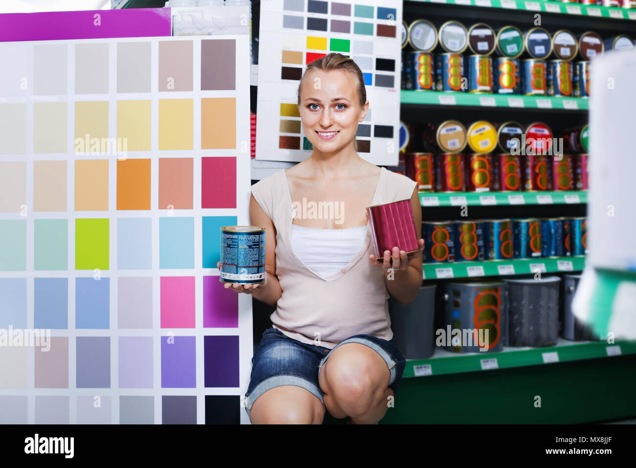 Positive smiling young woman choosing color for painting using palette ...