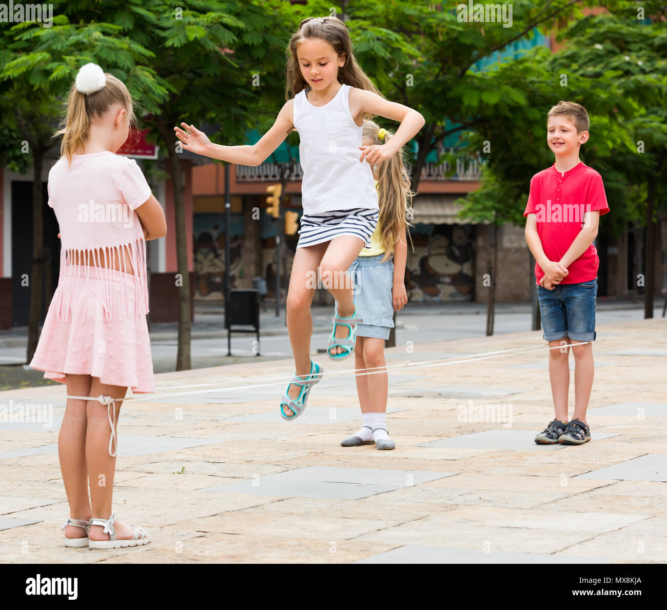 cheerful boy and girls in elementary school age jumping over chinese ...