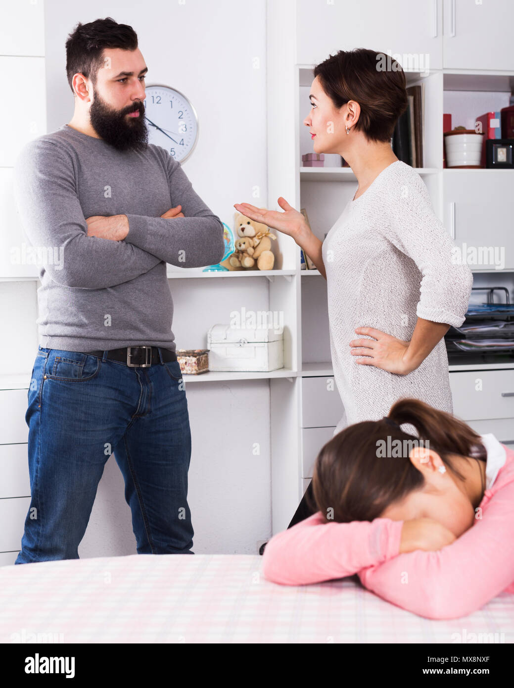 Young man and woman arguing with each other while their daughter at ...