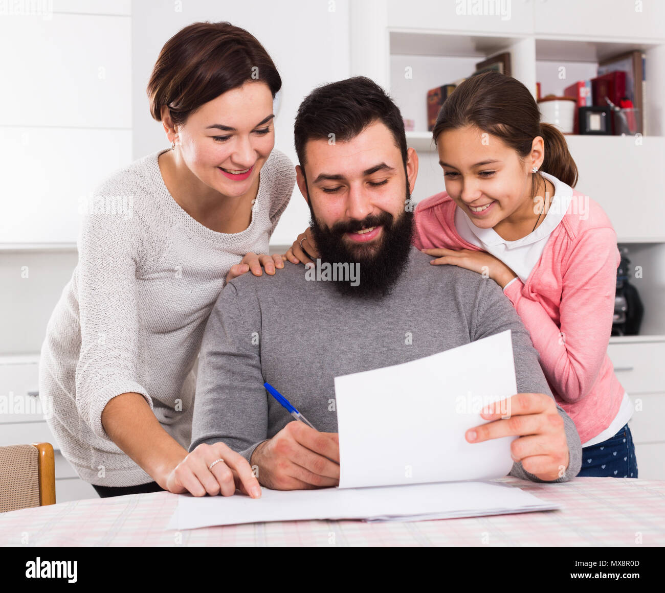 Father and mother preparing property papers with their daughter Stock ...