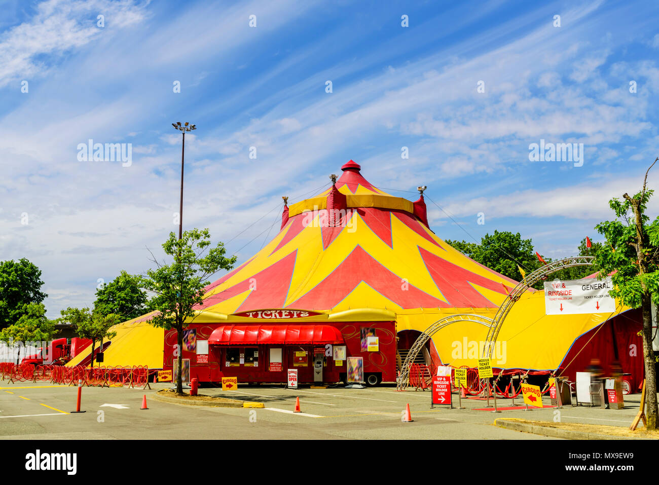 Domes of a caravan circus in the city, green trees, cars in a parking ...