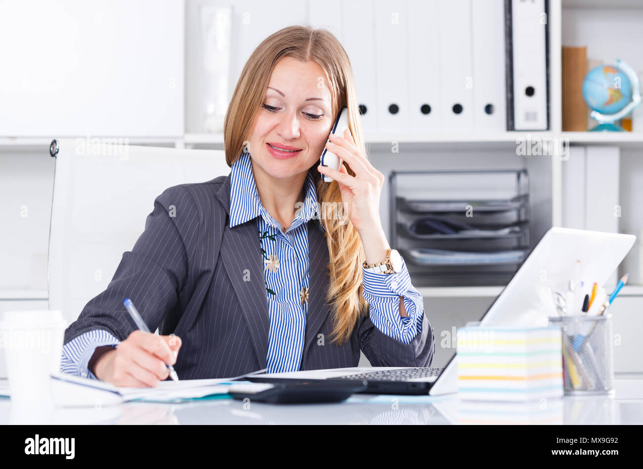 Elegant businesswoman having phone call conversation at workplace in ...