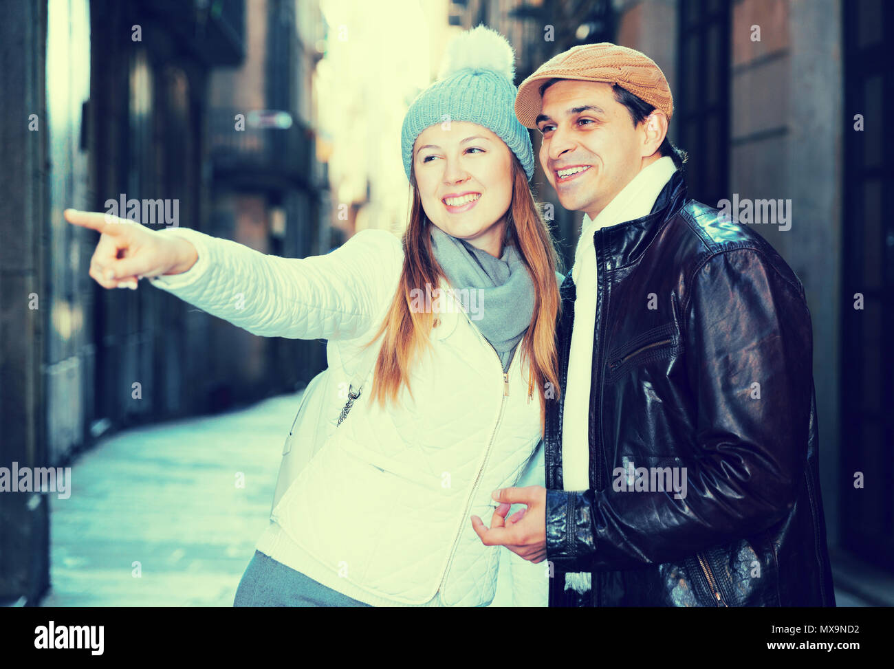 Adult tourists in hats and scarfs pointing finger on historical object ...