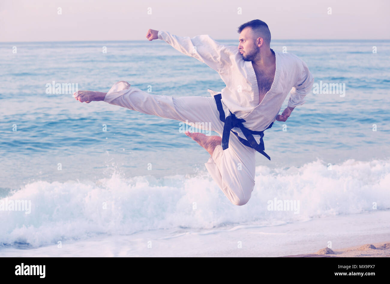 Man practising karate kata poses at seaside Stock Photo - Alamy