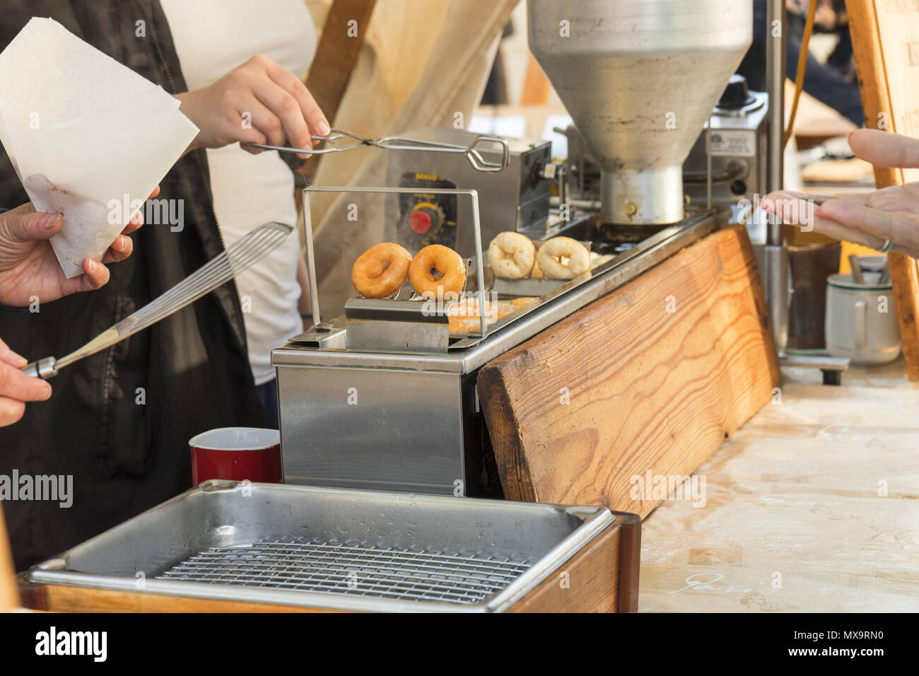 Street food market. Vendors at the street market make fresh donuts ...