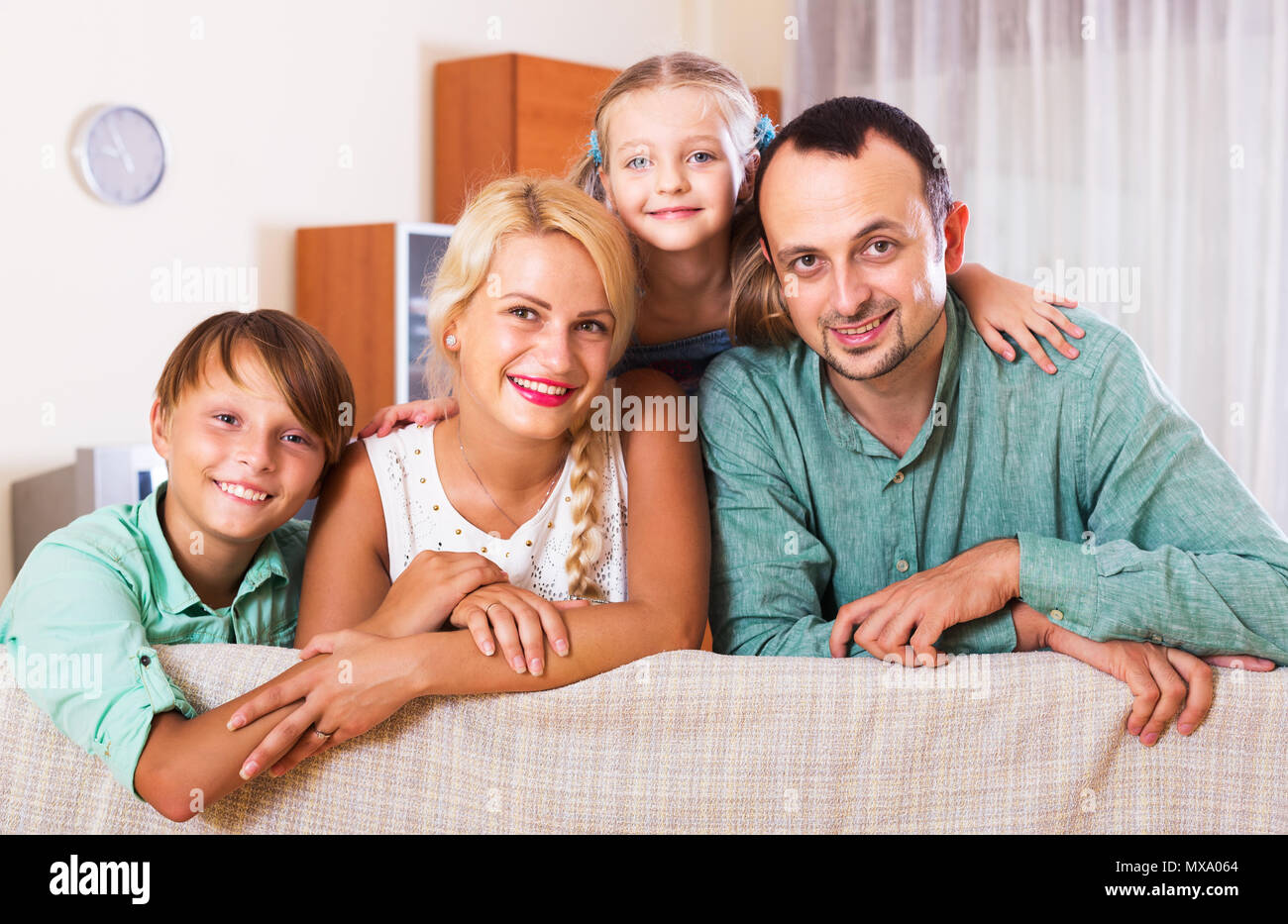 Portrait of happy middle class family at home interior. Focus on woman ...