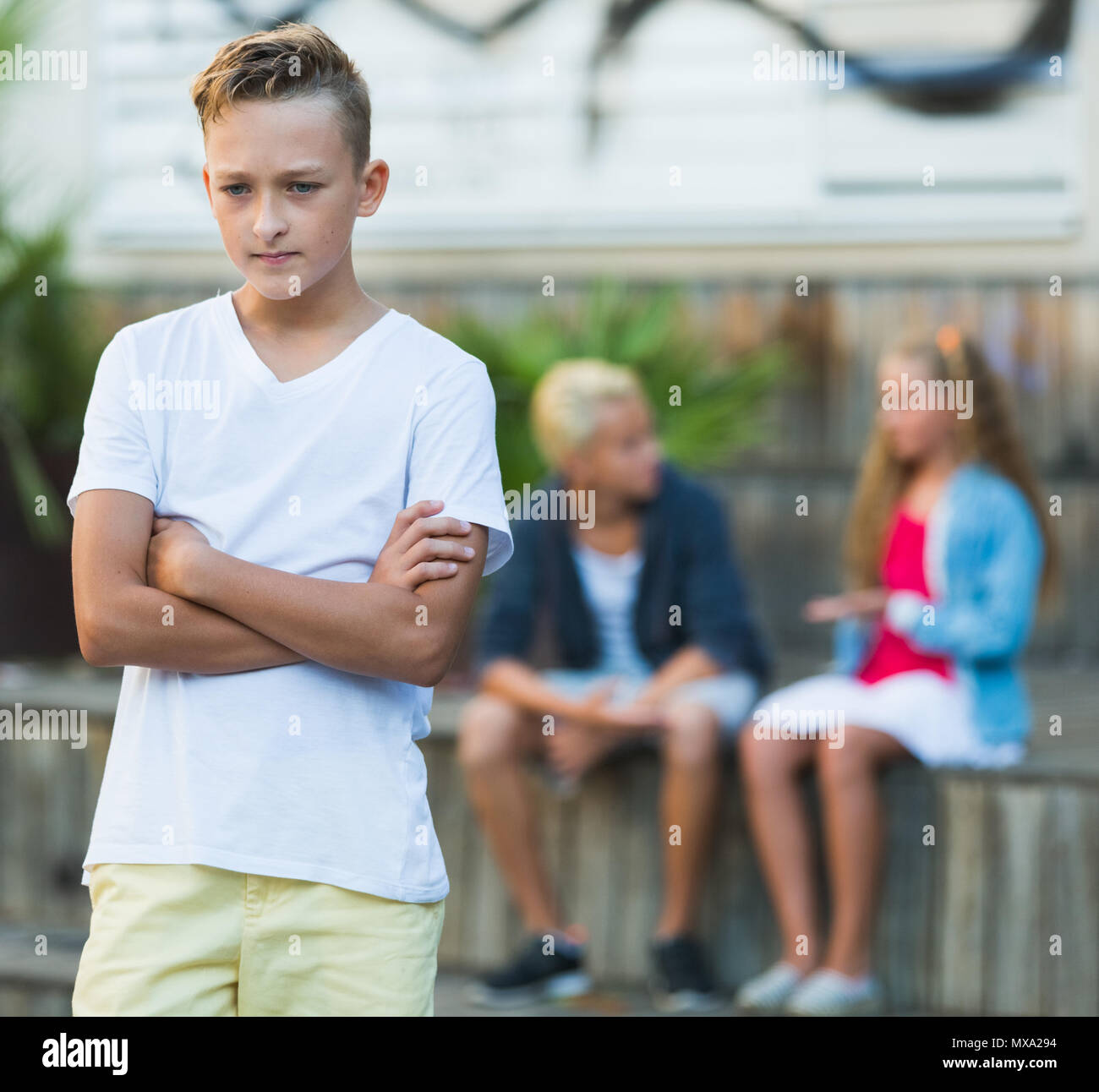 Portrait of offended boy not talking with friends after quarrel ...