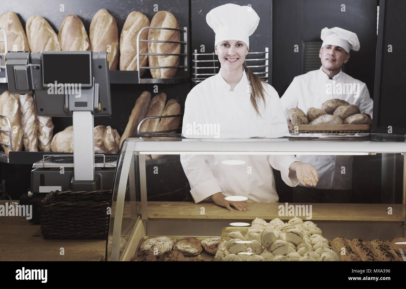 Bakery employees are offering tasty and fresh bread products in bakery ...