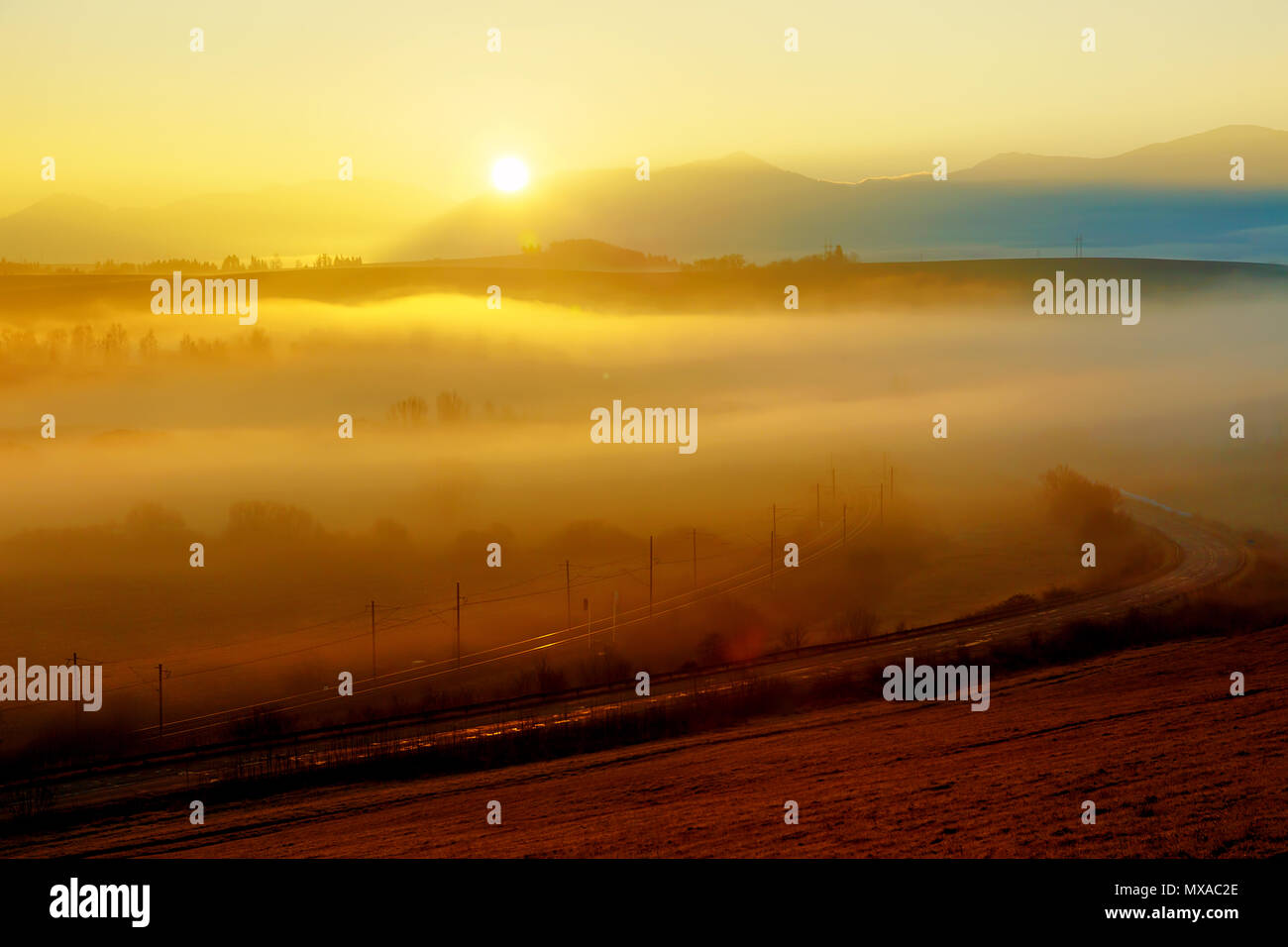 A beautiful morning landscape in fog with road and railway Stock Photo ...