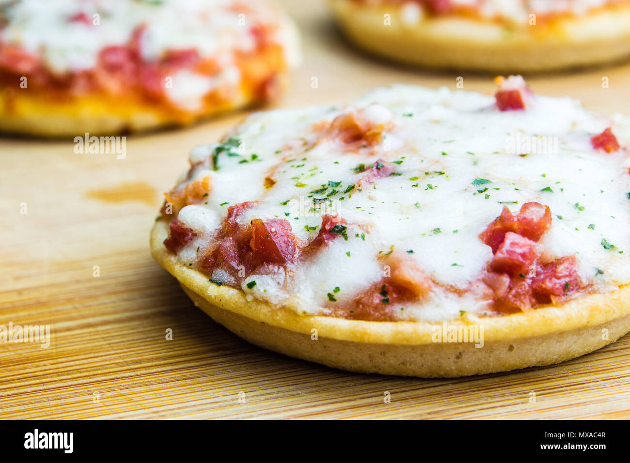 mini pizzas with ham and cheese on wooden plate Stock Photo - Alamy