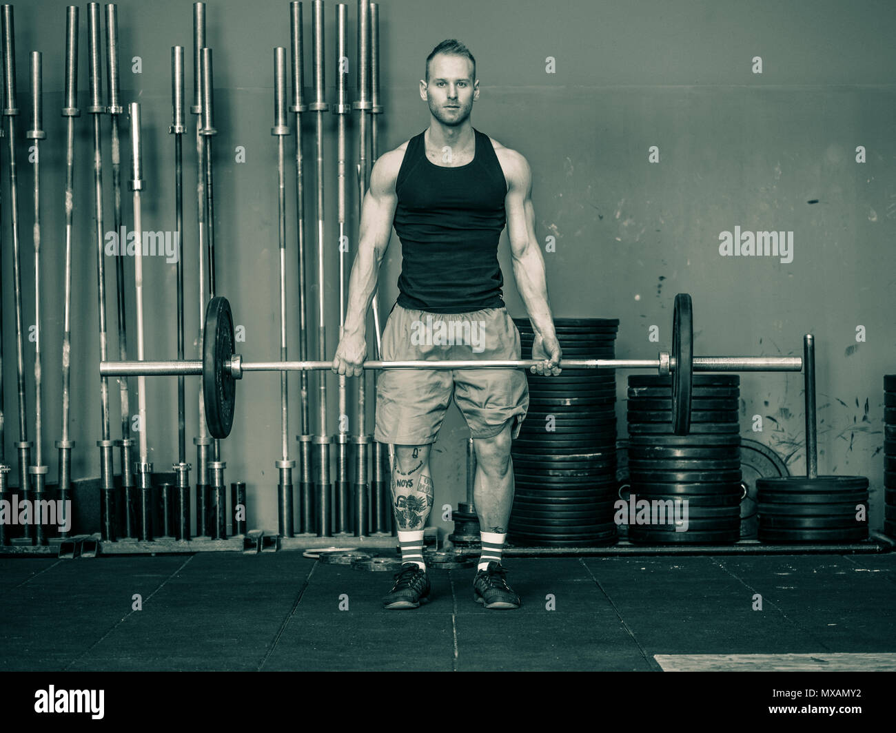 Young man training legs in gym Stock Photo - Alamy