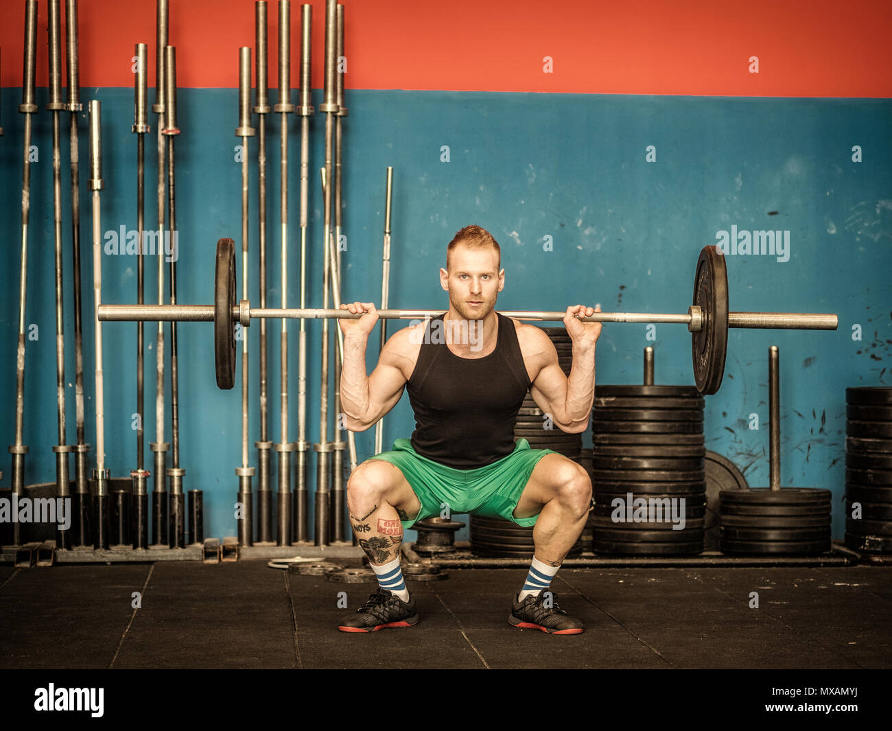 Young man training legs in gym Stock Photo - Alamy
