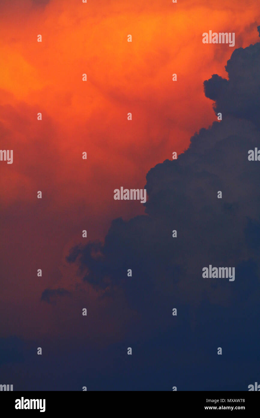 Blue and red clouds meets in the air at sunset time Stock Photo - Alamy