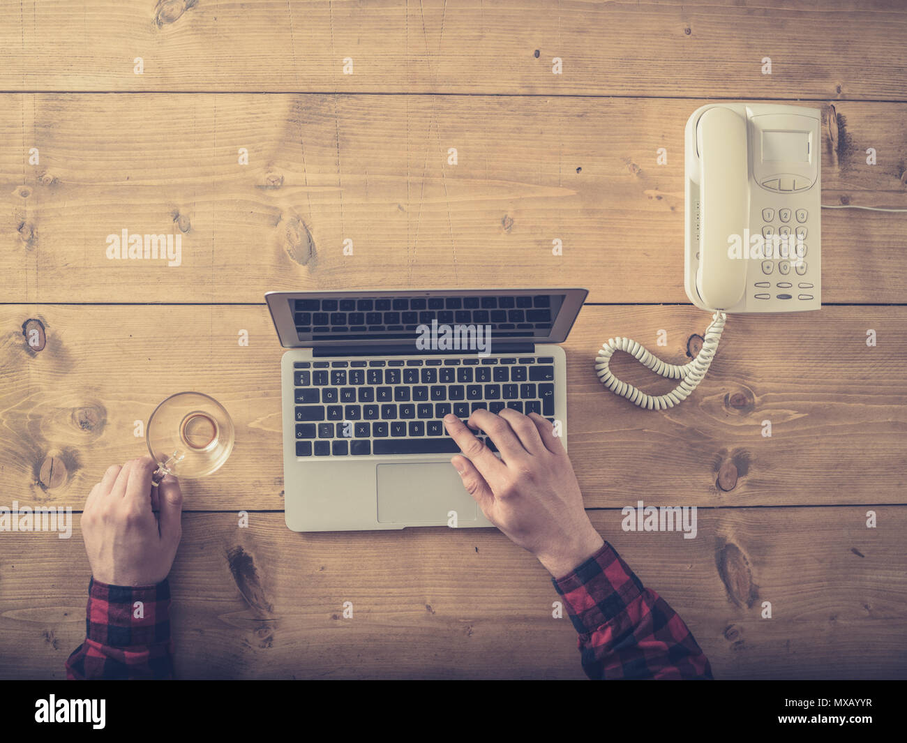 Overhead shot of a man using a laptop and an old wired telephone Stock ...