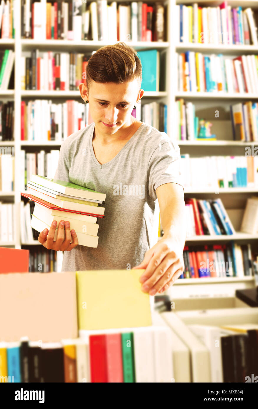 Boy choosing book from library hi-res stock photography and images - Alamy
