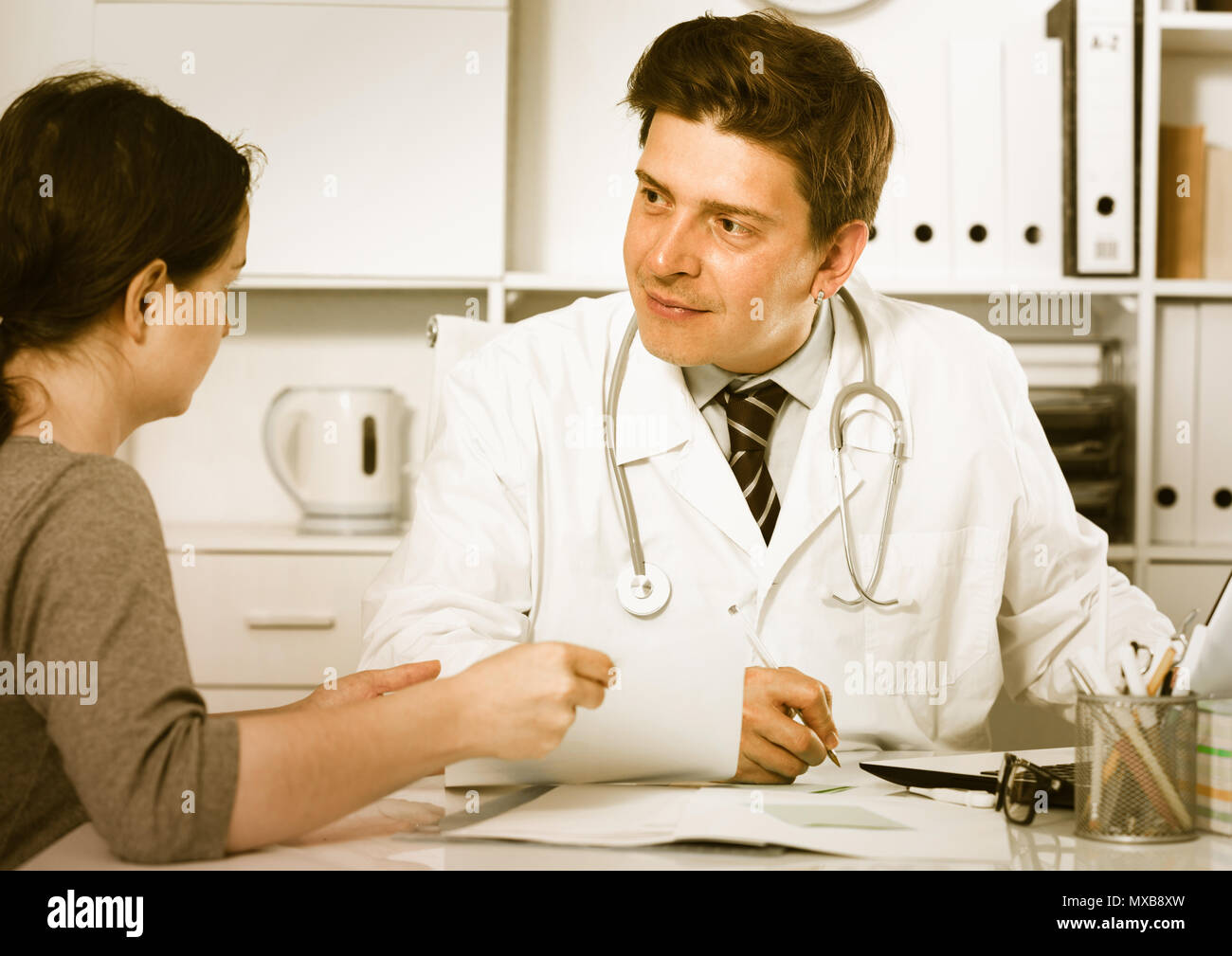 Happy cheerful doctor speaking with client in the medical center Stock ...