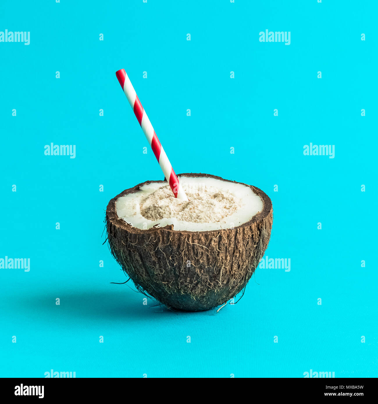Coconut full of sand with drinking straw tropical drink minimal ...