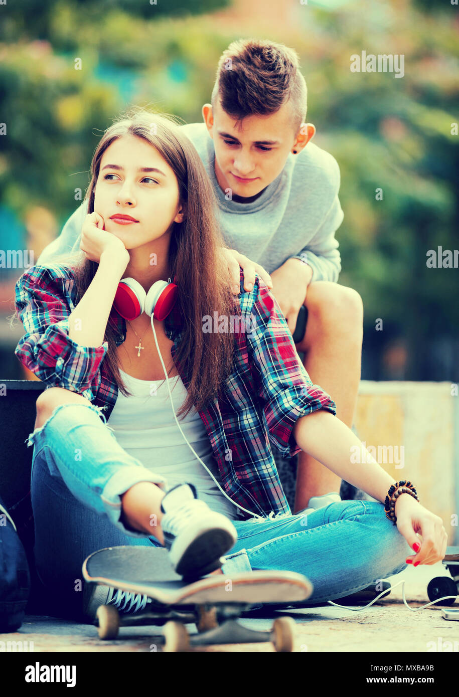 Boy apologizes to her girl after an argument outdoor. Focus on the girl ...